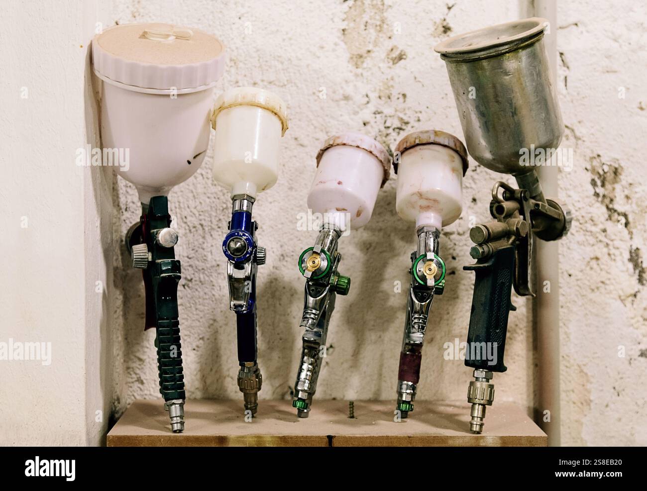 A collection of airbrushes and paint sprayers neatly arranged in a bass ...