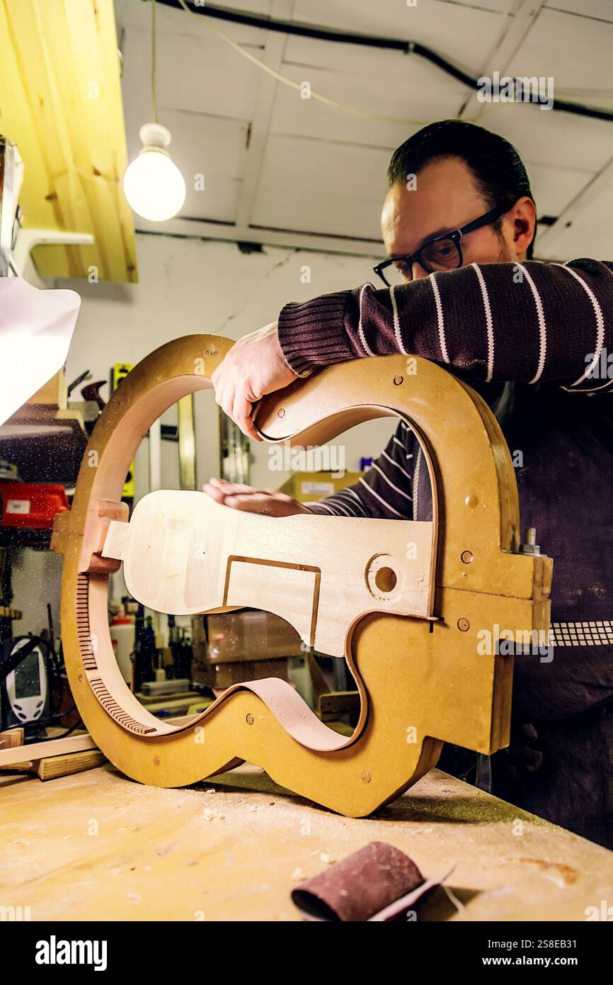 A skilled luthier at work in a workshop, carefully crafting a bass ...