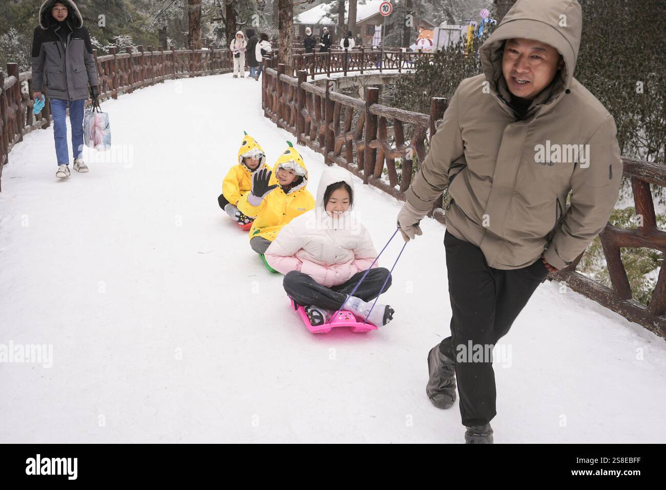 (250122) -- CHENGDU, Jan. 22, 2025 (Xinhua) -- A parent takes children ...