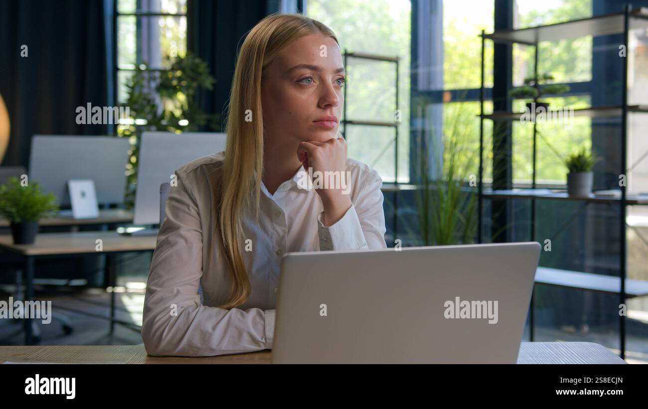 Portrait dreaming Caucasian businesswoman at office desk thoughtful ...