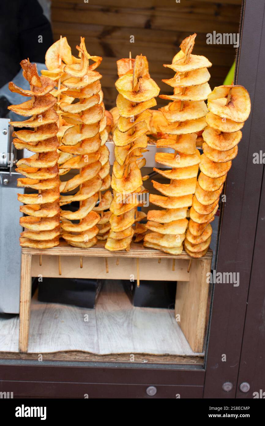 Potato chips on a skewer. Spiral potatoes fried, on wooden sticks ...