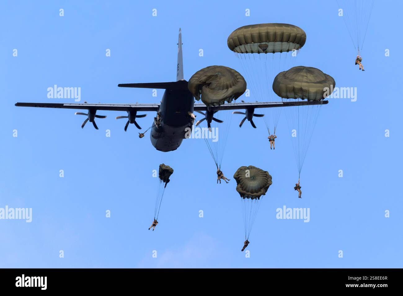 Military parachutist paratroopers parachute jumping out of an air force ...