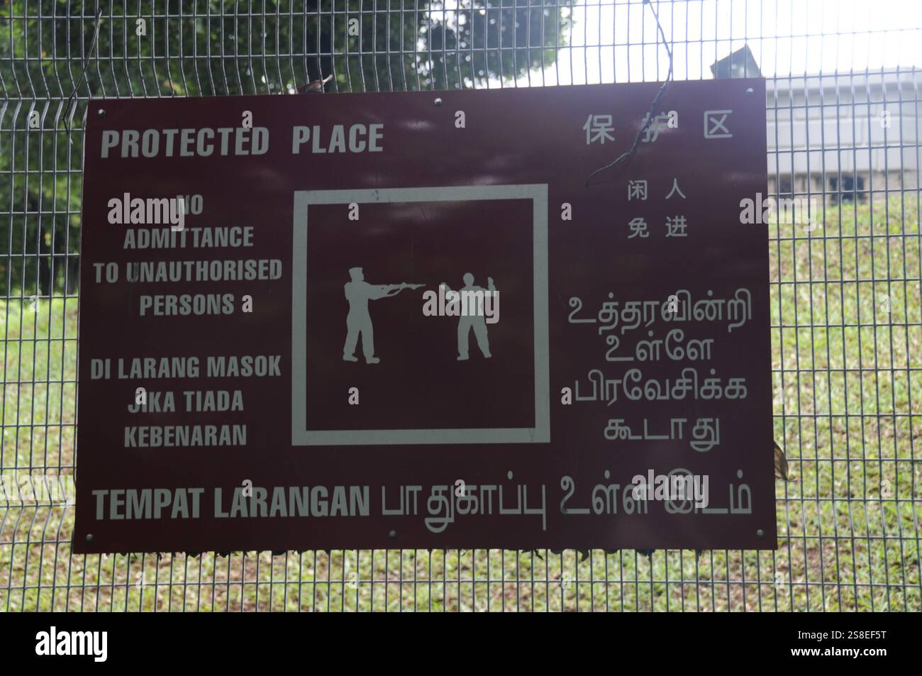 A security warning sign attached to a high ring fence in Singapore ...
