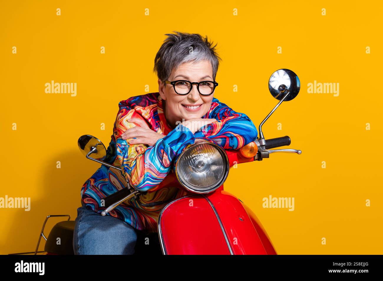 Portrait of pretty aged lady sitting scooter isolated on yellow color ...