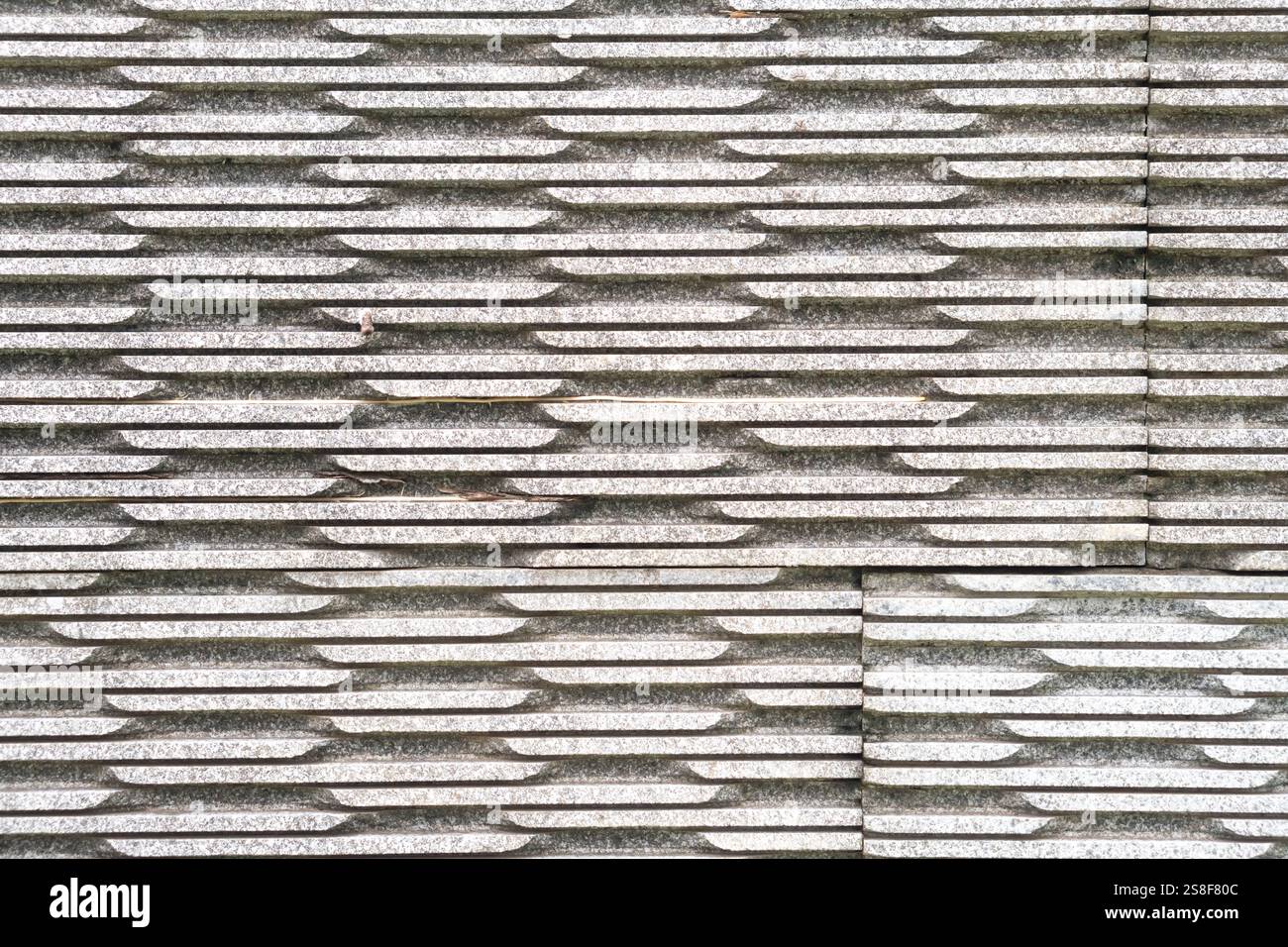 A textured wall made of interlocking stone blocks, featuring a ...