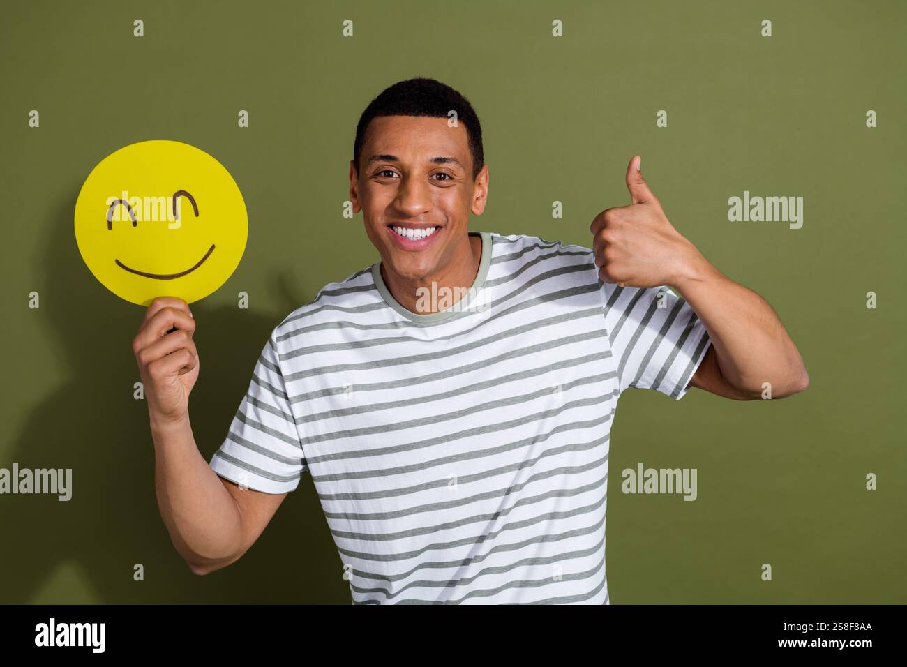 Photo of funky cool guy dressed striped t-shirt showing thumb up ...