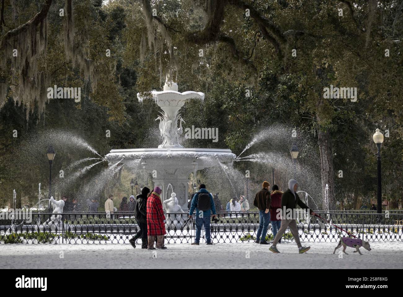 Despite a rare snow fall in the South, people walk around the historic ...