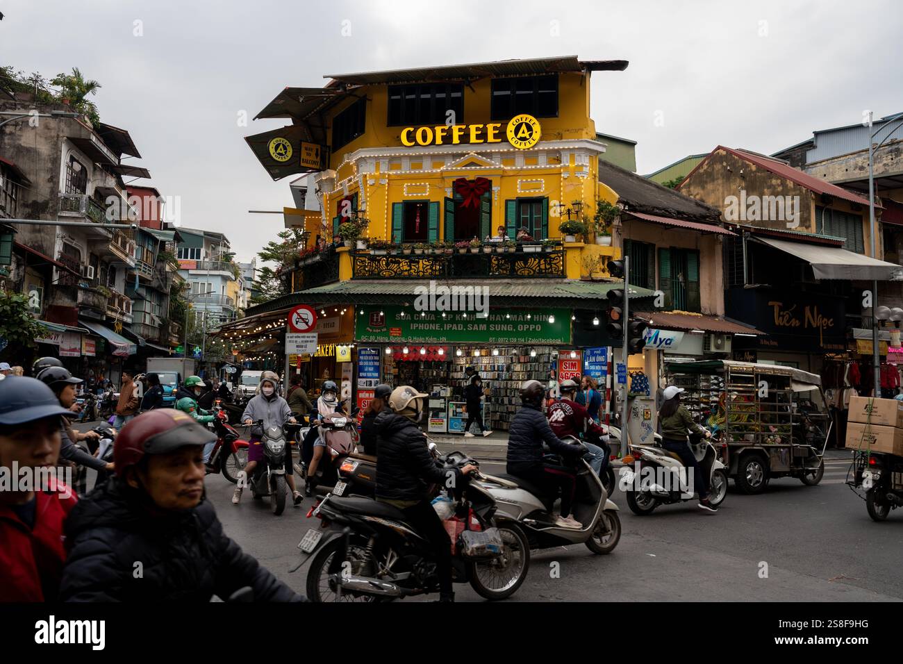 Traffic, French colonial buildings and people on motorbikes in the old ...