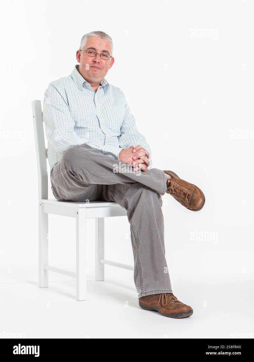 Relaxed and friendly body language from a casually dressed man seated ...