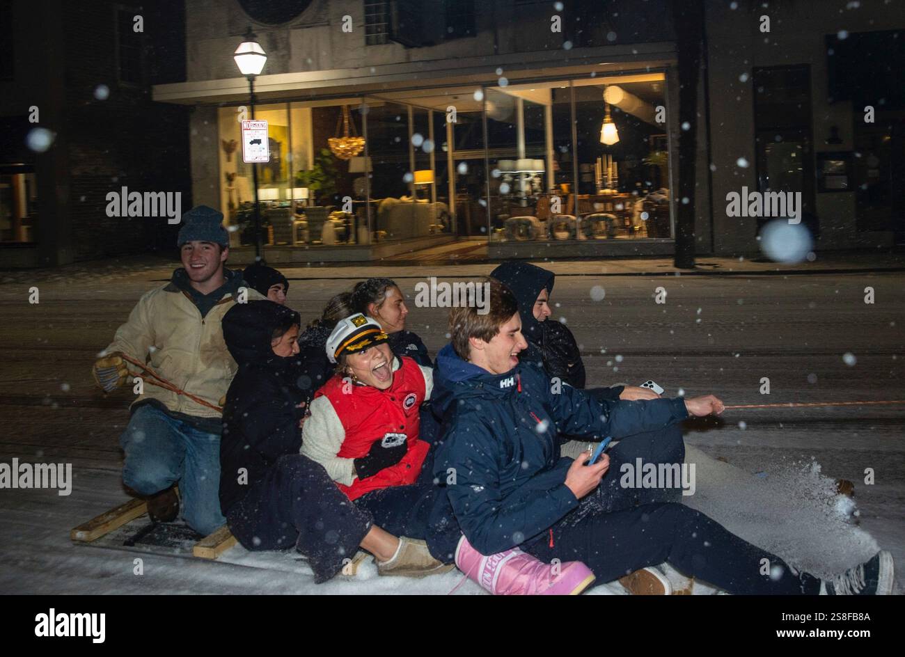 People ride a sled along King Street in the snow Tuesday, Jan. 21, 2025 ...