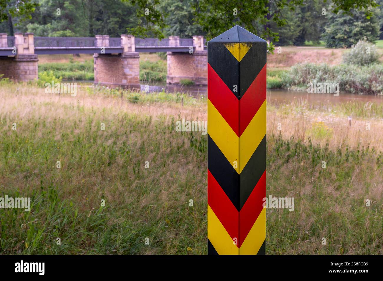 Deutscher Grenzpfosten vor einer Brücke über die Neiße im Fürst-Pückler ...