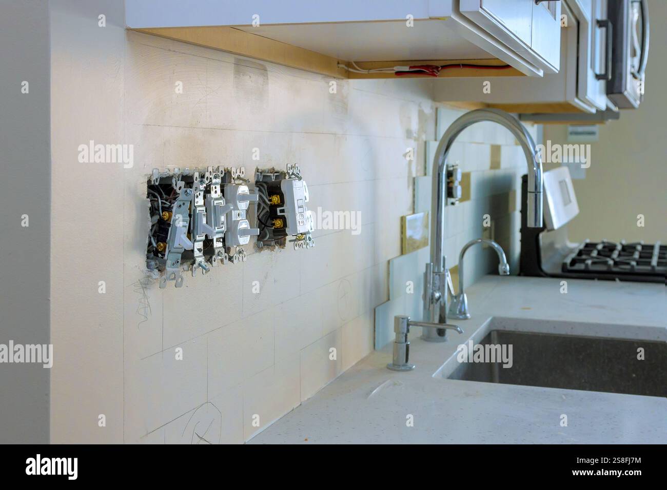 Workers install electrical outlets in kitchen renovation, showcasing ...