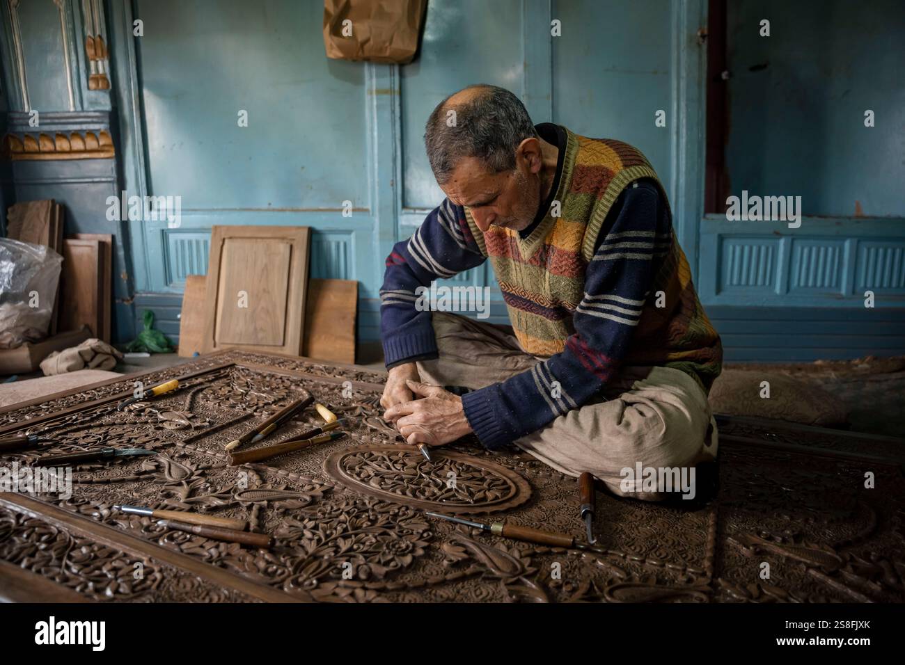 A craftsman is seen using a tool to brighten and polish a wood-crafted ...