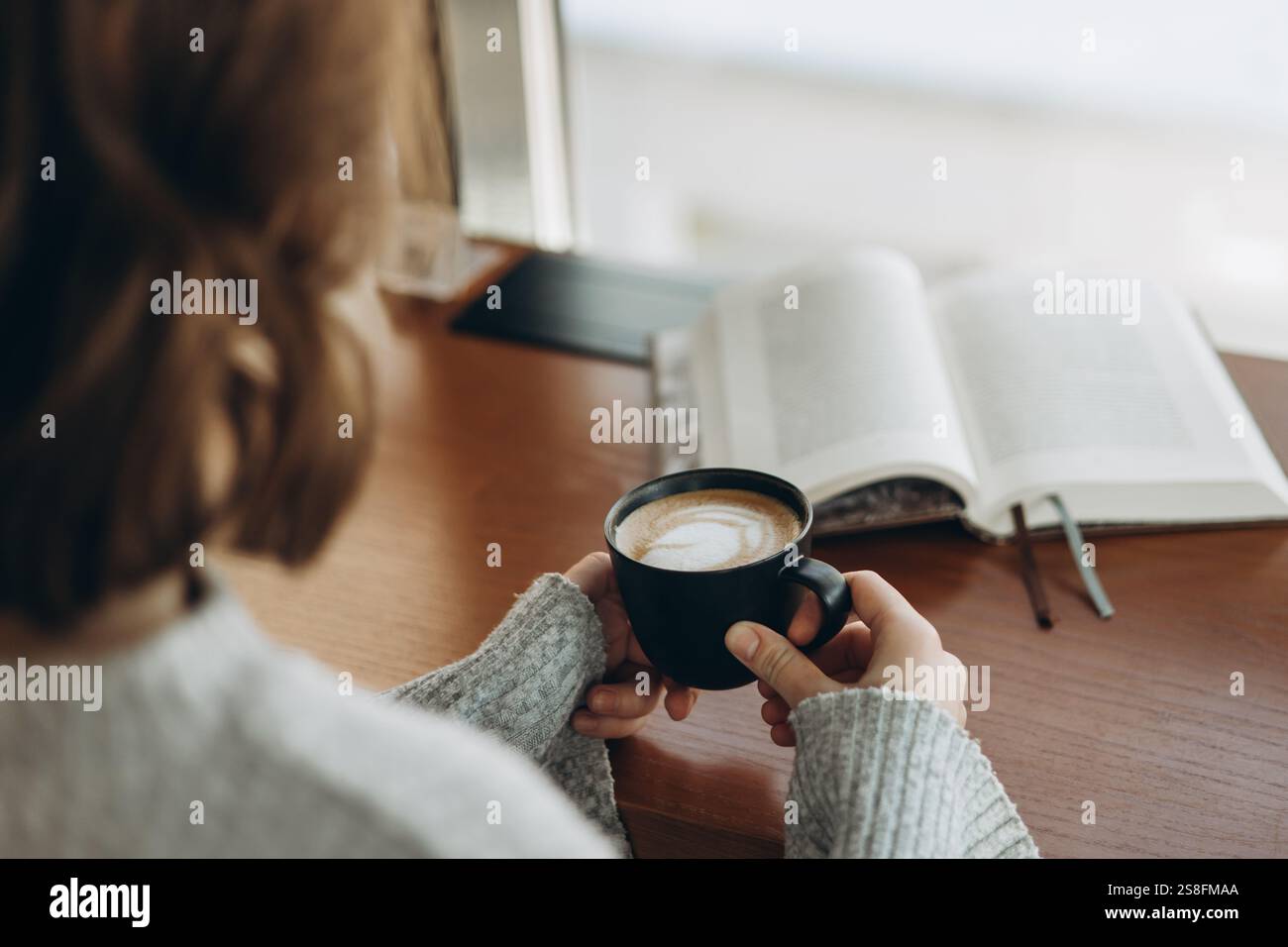 A relaxing scene featuring a person holding a steaming cup of coffee ...
