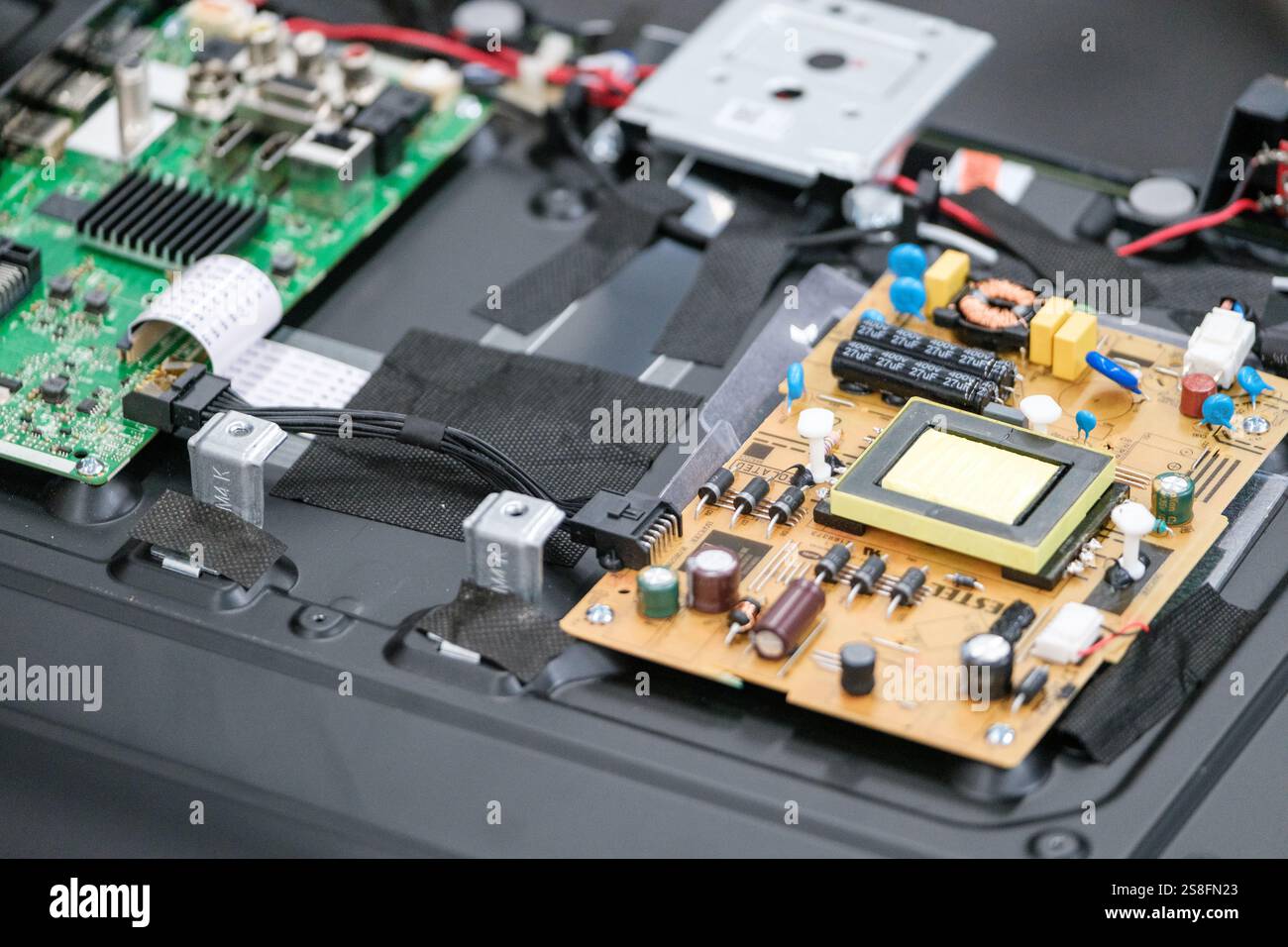 Close-up image of a TV circuit board during a repair process The ...
