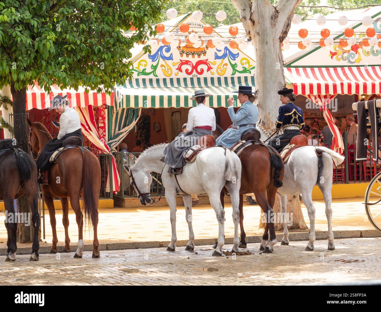 Group of Spanish riders in traditional attire on horseback at an ...