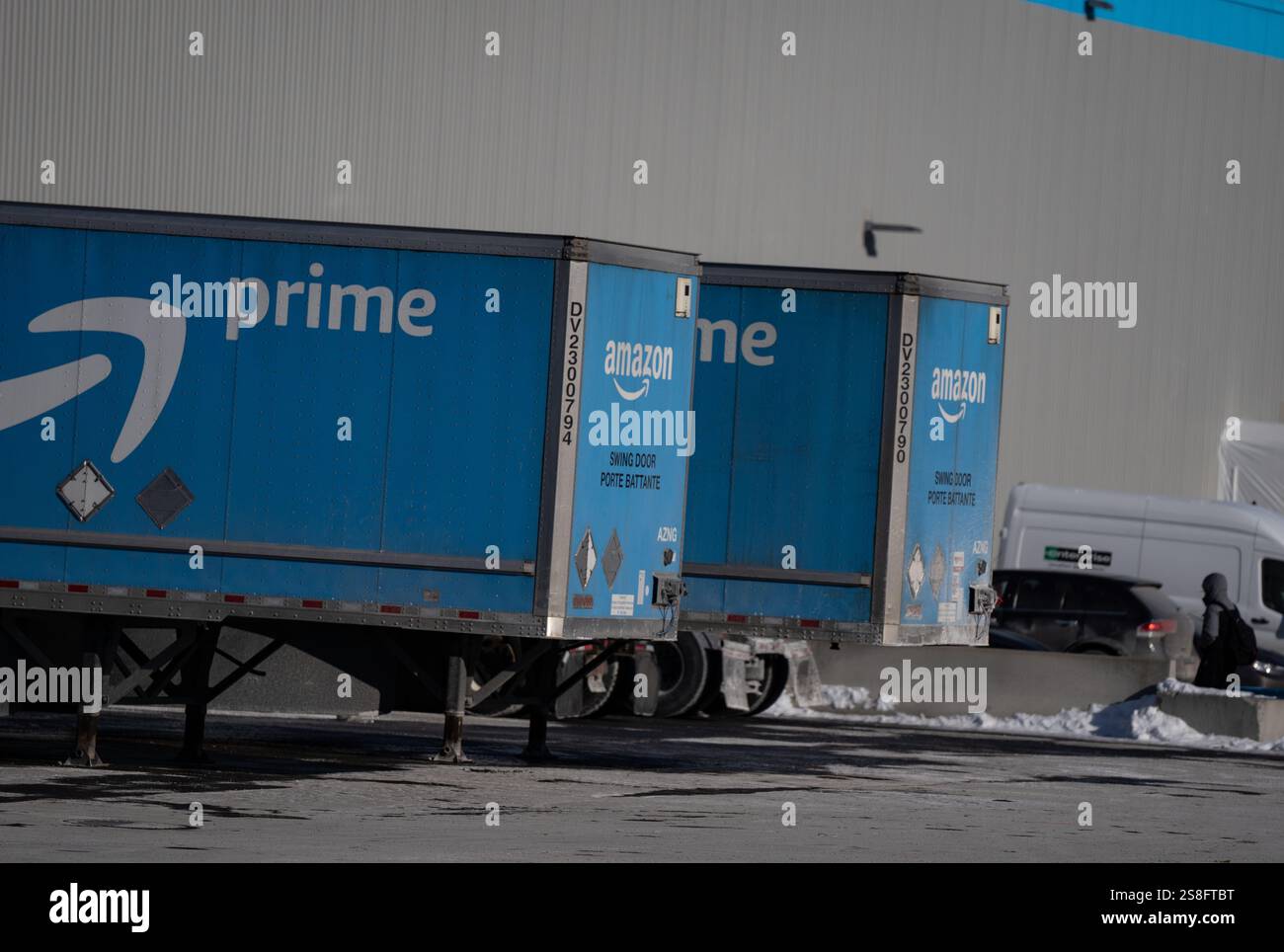 Laval, Canada. 22nd Jan, 2025. An employee walks past trucks at Amazon ...
