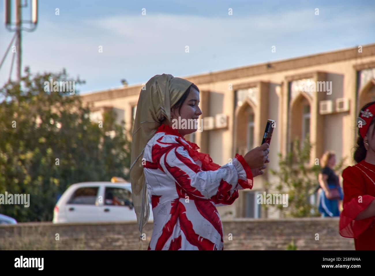 Bukhara,Uzbekistan; September,19,2024:an Uzbek woman wearing a vibrant ...