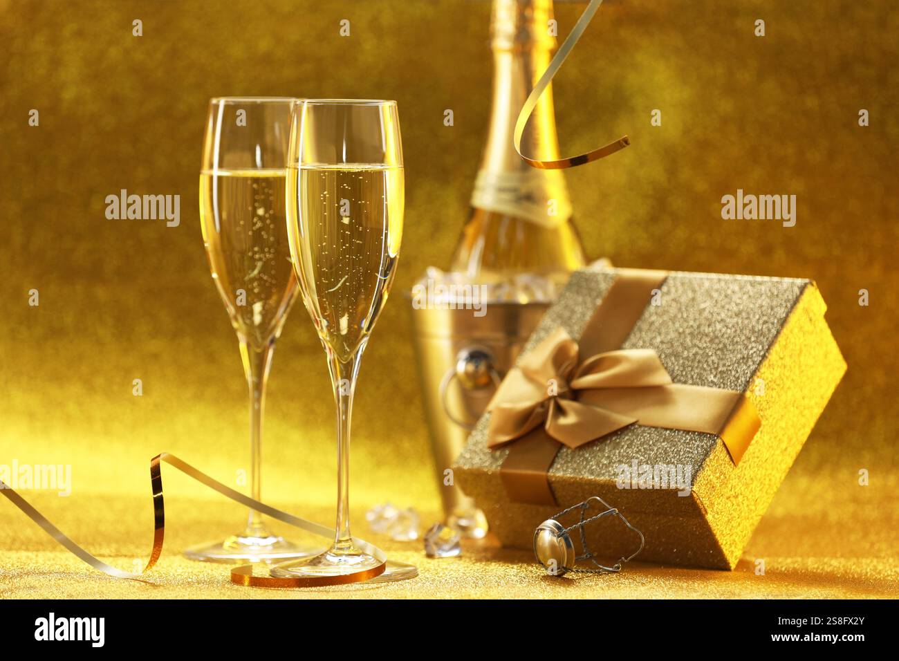 Champagne, gift box and streamers on golden background Stock Photo - Alamy