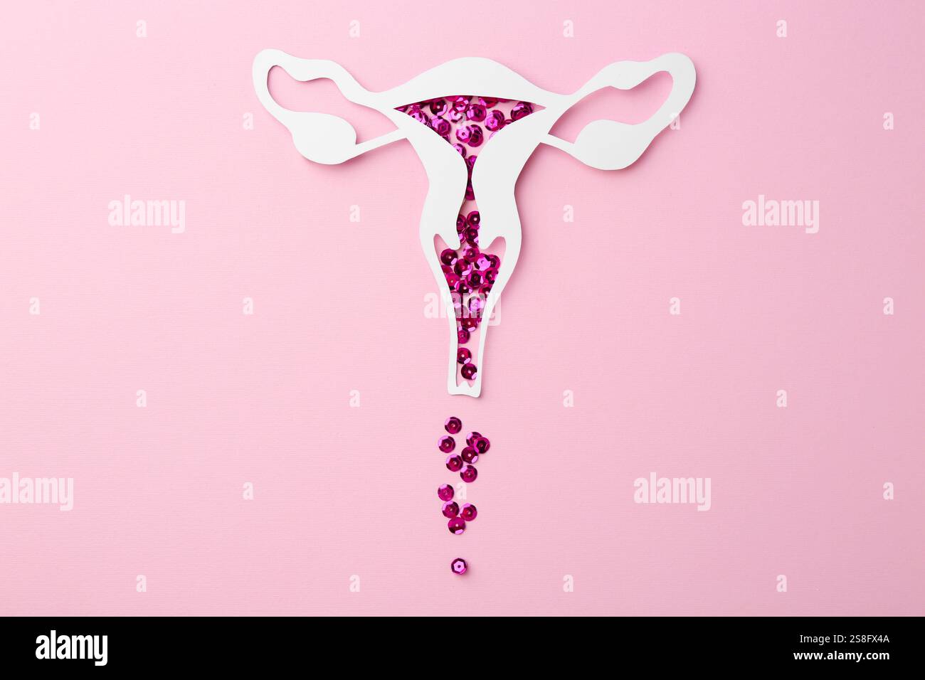Menstruation. Paper uterus with sequins on pink background, top view ...