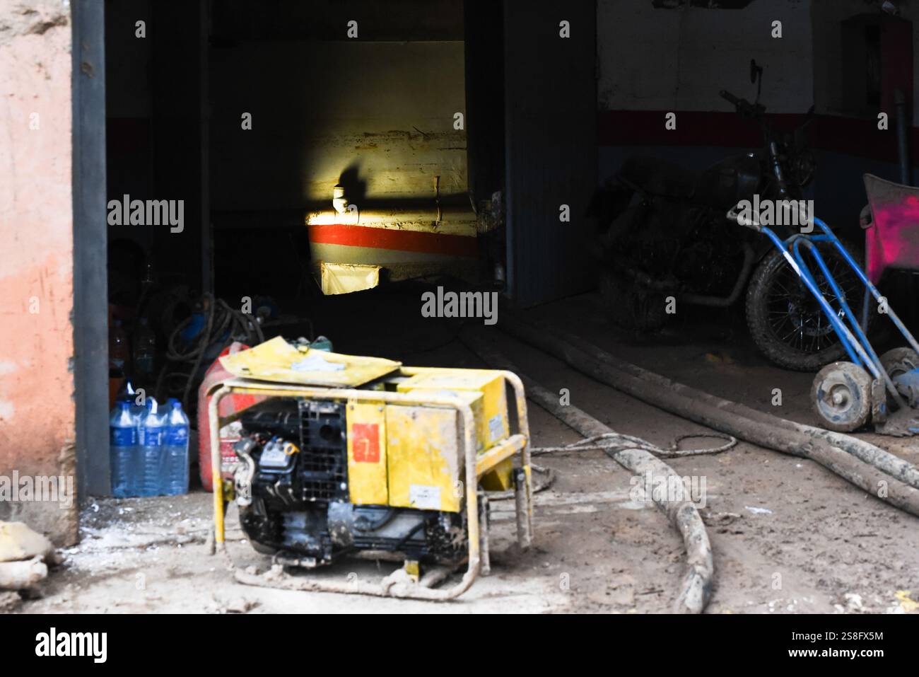 Current generator at the entrance covered in mud of a garage after DANA ...