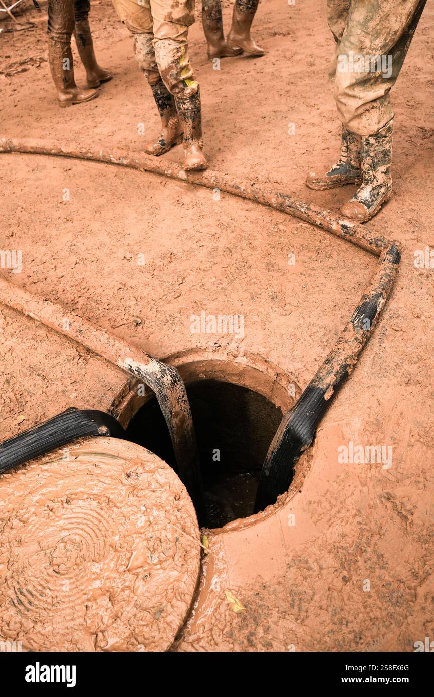 muddy gumboots of unrecognizable people working at mud suction from the ...