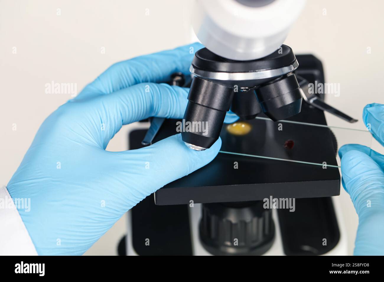 Scientist examining sample on slide under microscope, closeup Stock ...