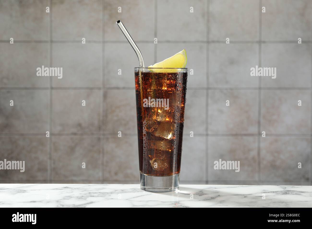 Refreshing iced cola with lime slice on white marble table Stock Photo ...