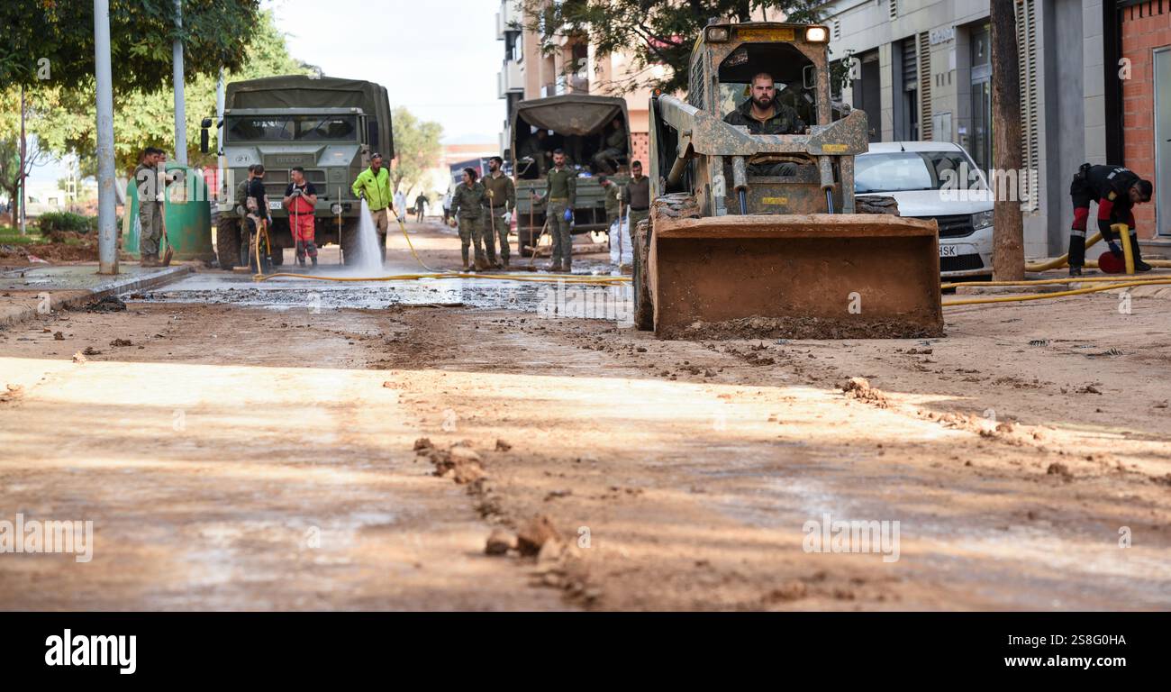 Military Army members and mini excavator during cleanup operations ...