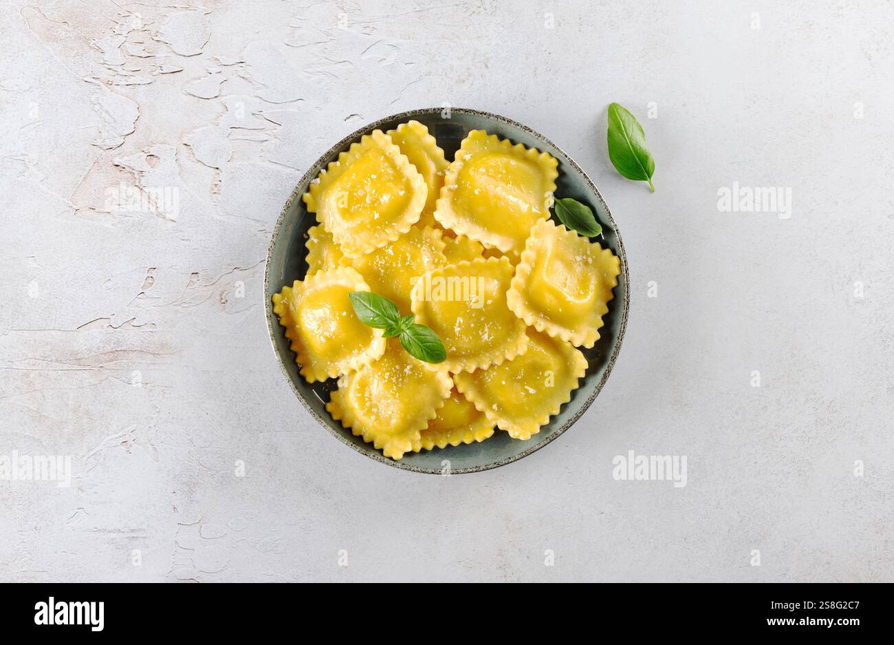 Cheese ravioli filling ricotta, gorgonzola and fresh basil on grey ...