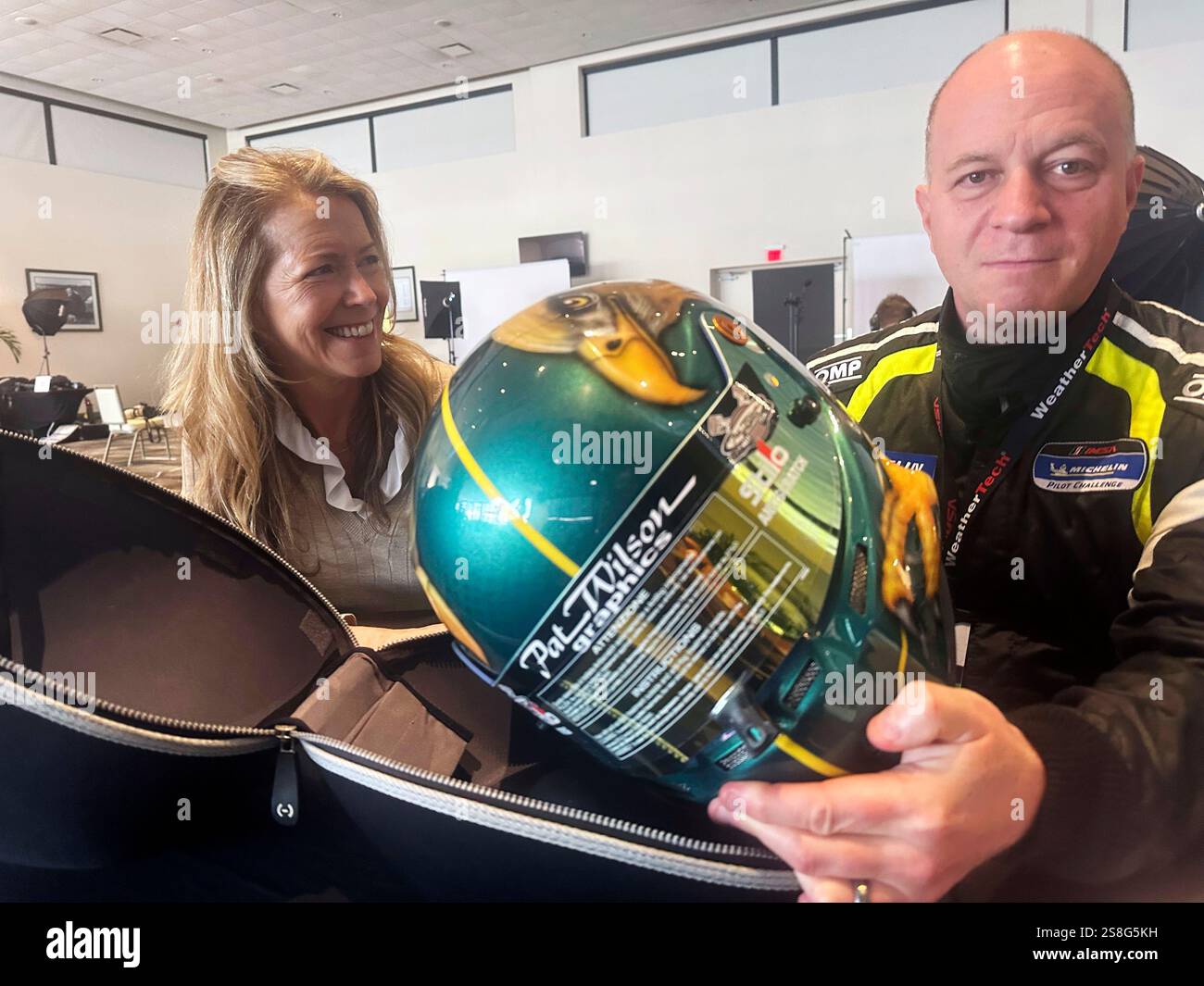 Tech executive and part-time racer Ben Sloss shows off the helmet ...