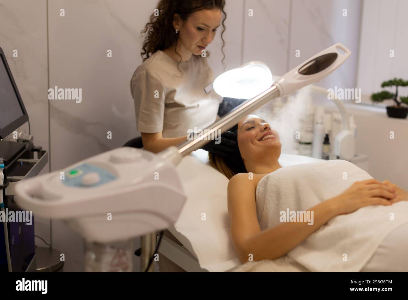 A tranquil spa setting features a woman enjoying a facial treatment ...
