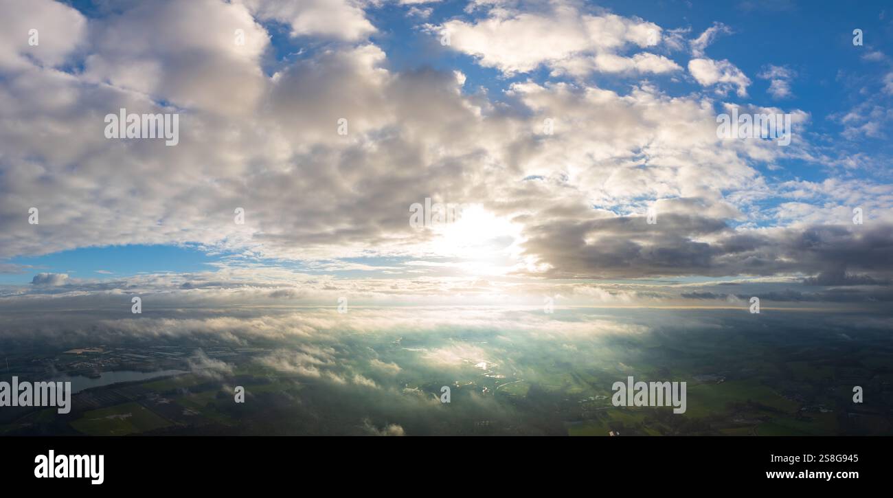 aerial photo of the sun shining above a foggy landscape Stock Photo - Alamy