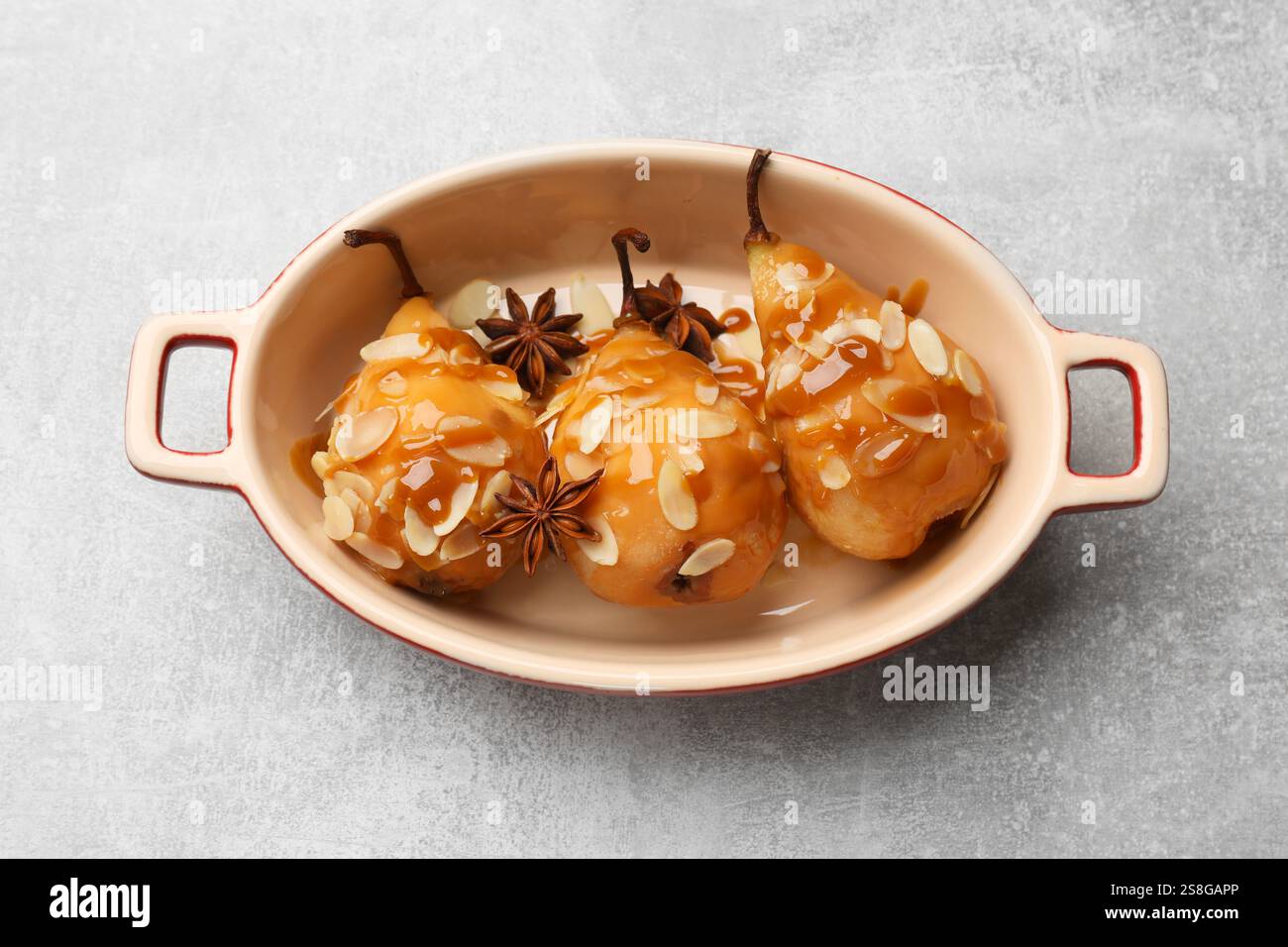 Delicious pears with caramel sauce, almond flakes and anise stars on ...