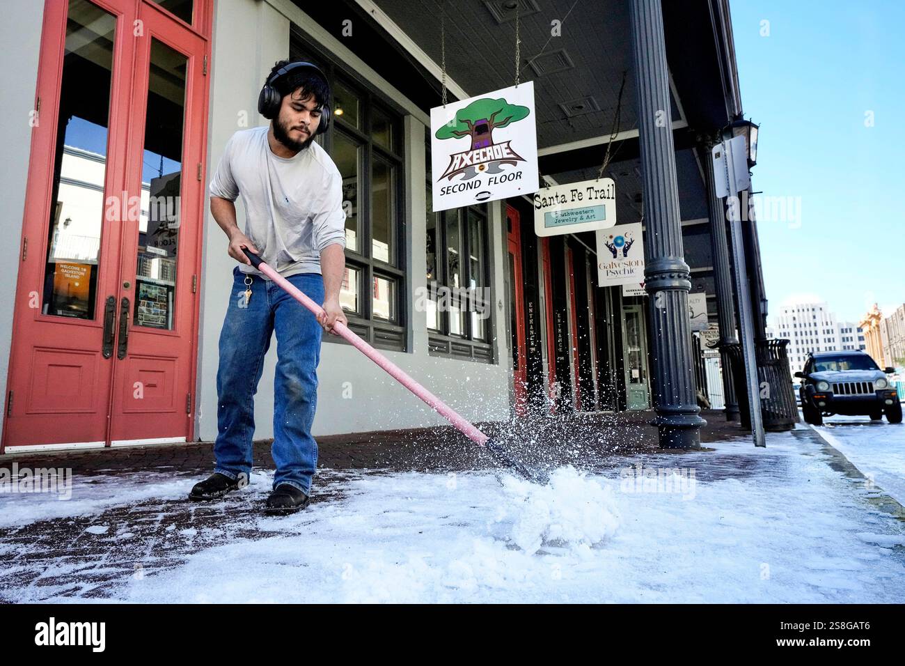 Adiel Santos, of Mitchell Historic Properties, scrapes ice and snow ...