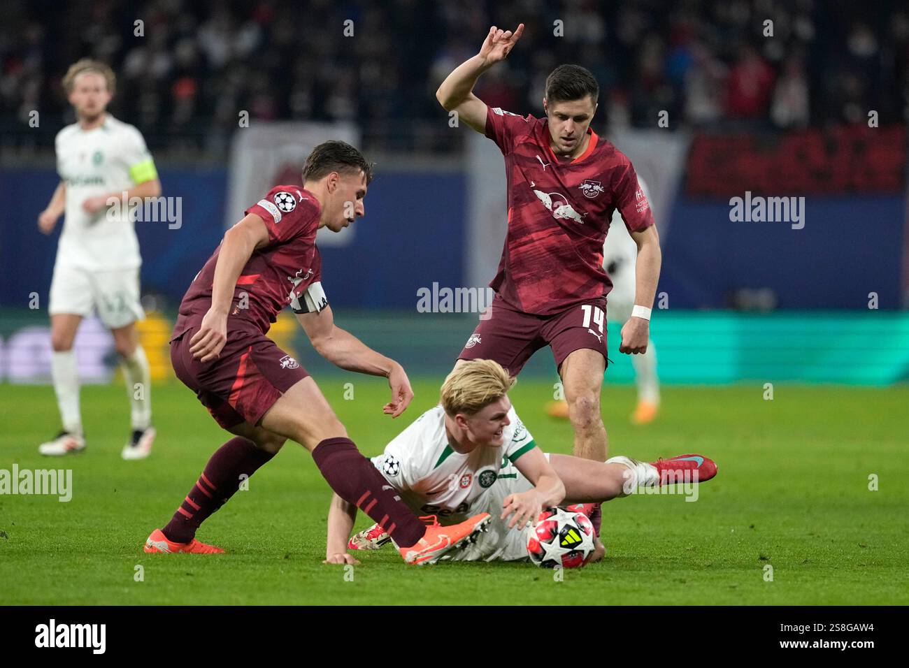 Sporting's Conrad Harder, bottom, challenges for the ball with Leipzig ...