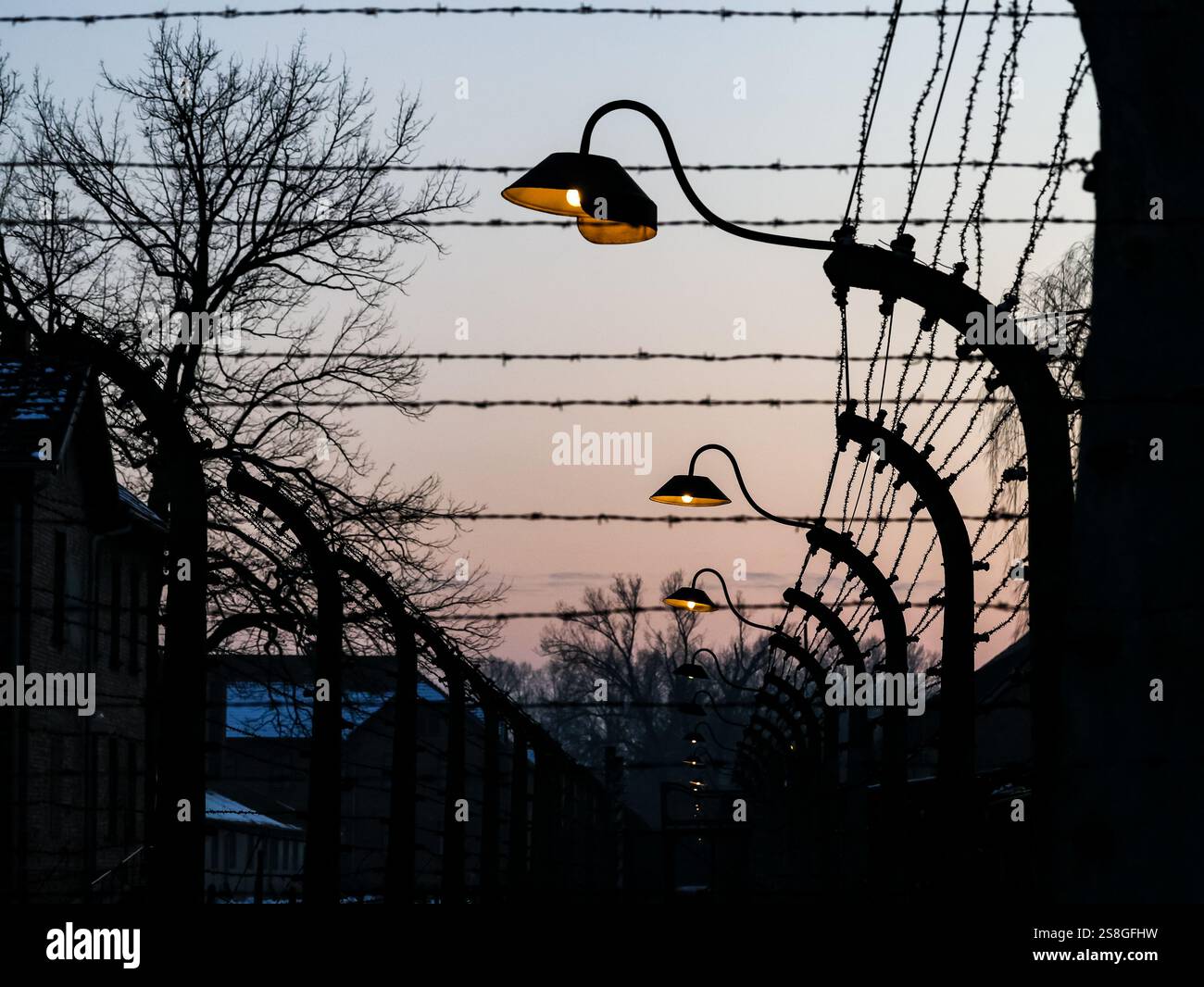 Oswiecim, Poland, on January 22, 2025.A sunset is seen against barbed ...