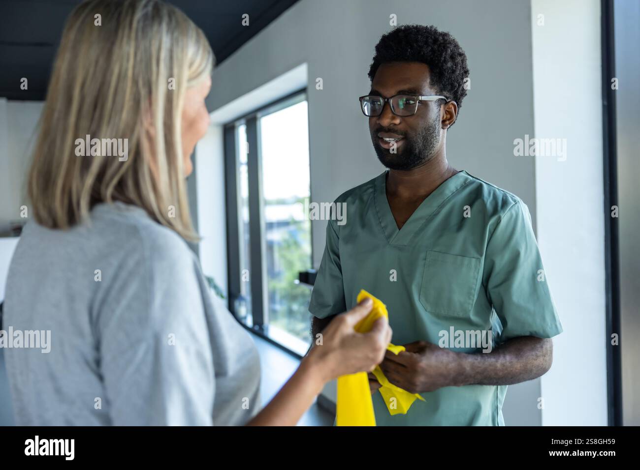 Female therapist talking with patient during rehabilitation session in ...