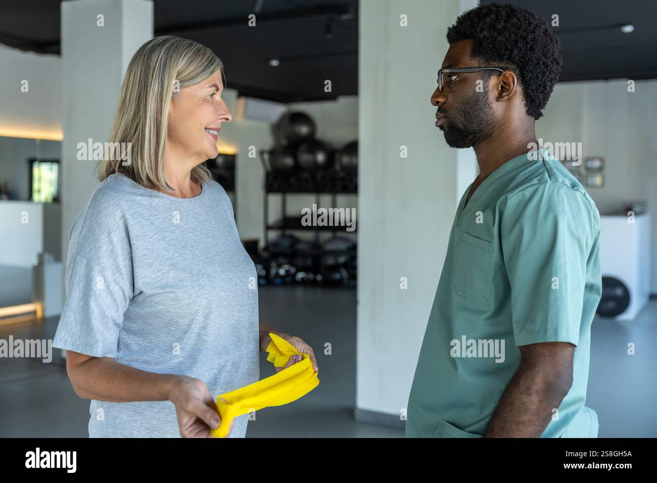 Female therapist talking with patient during rehabilitation session in ...