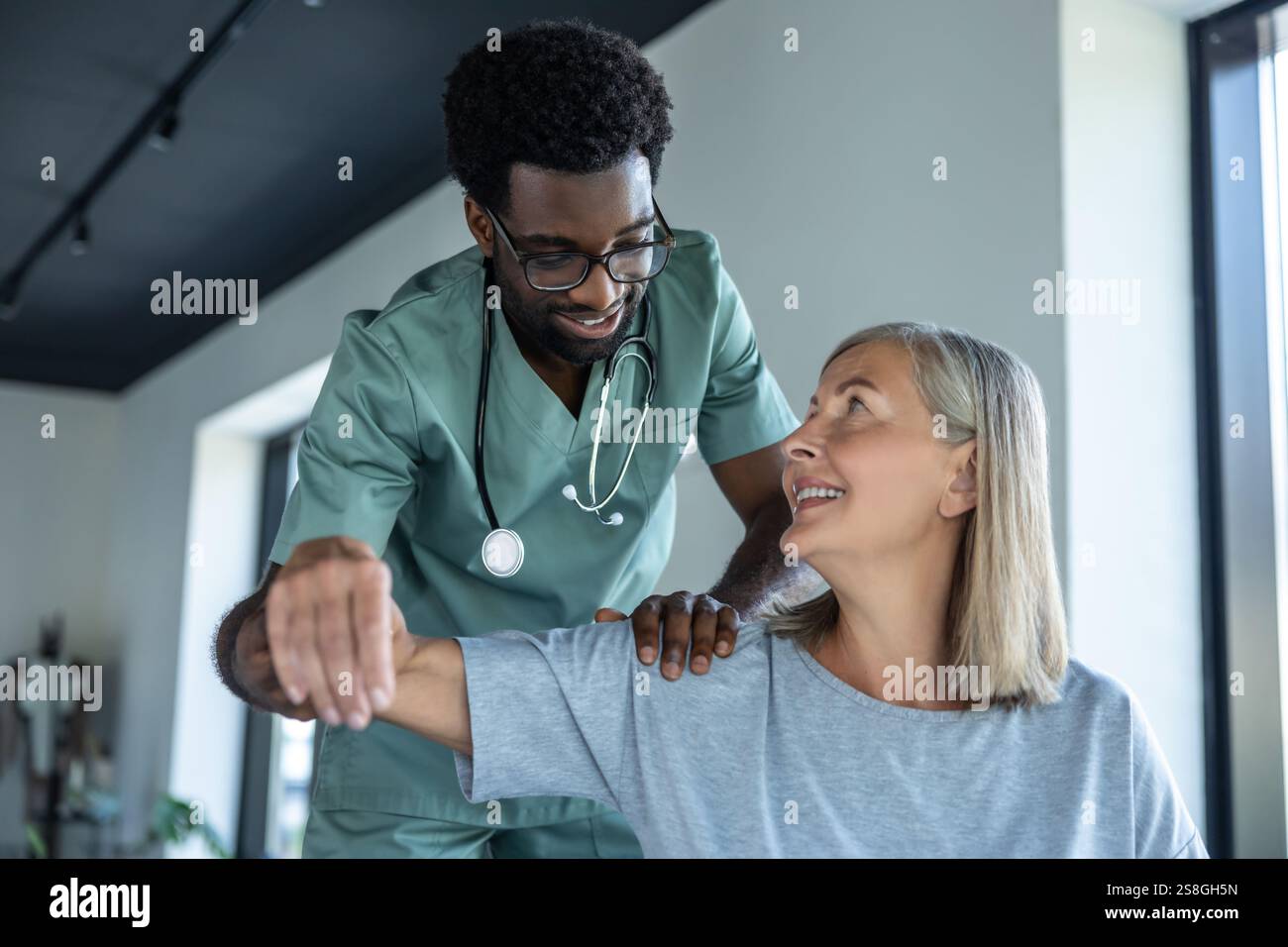 Bearded male doctor working with senior patient in clinic providing ...
