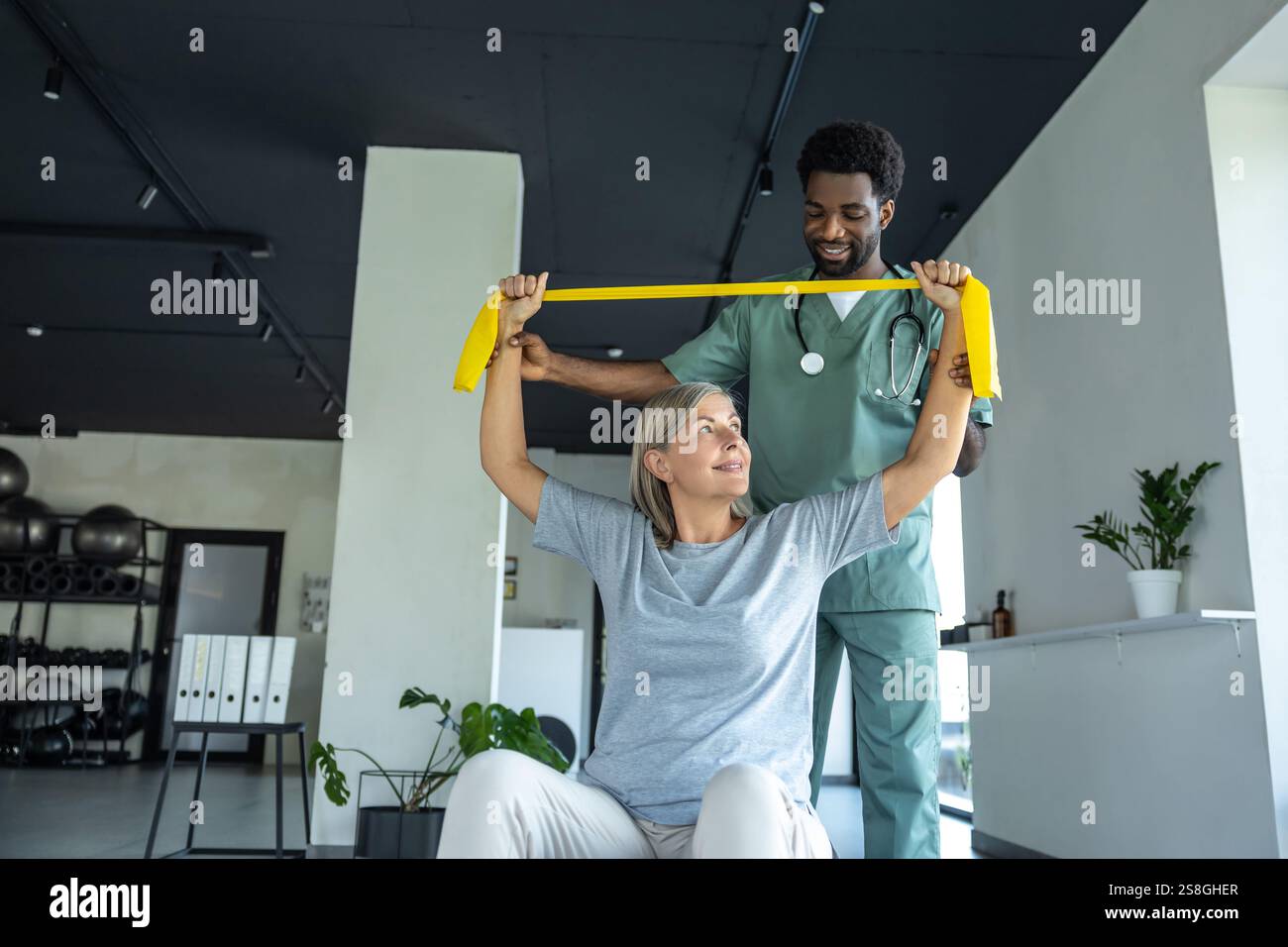 Man physiotherapist exercising with patient in therapy session for ...