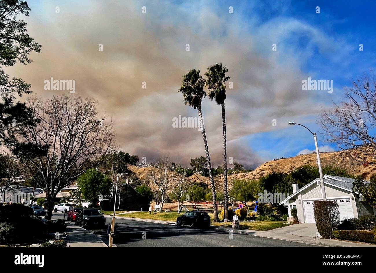 A large plume of smoke rises from Castaic Lake seen behind a ...
