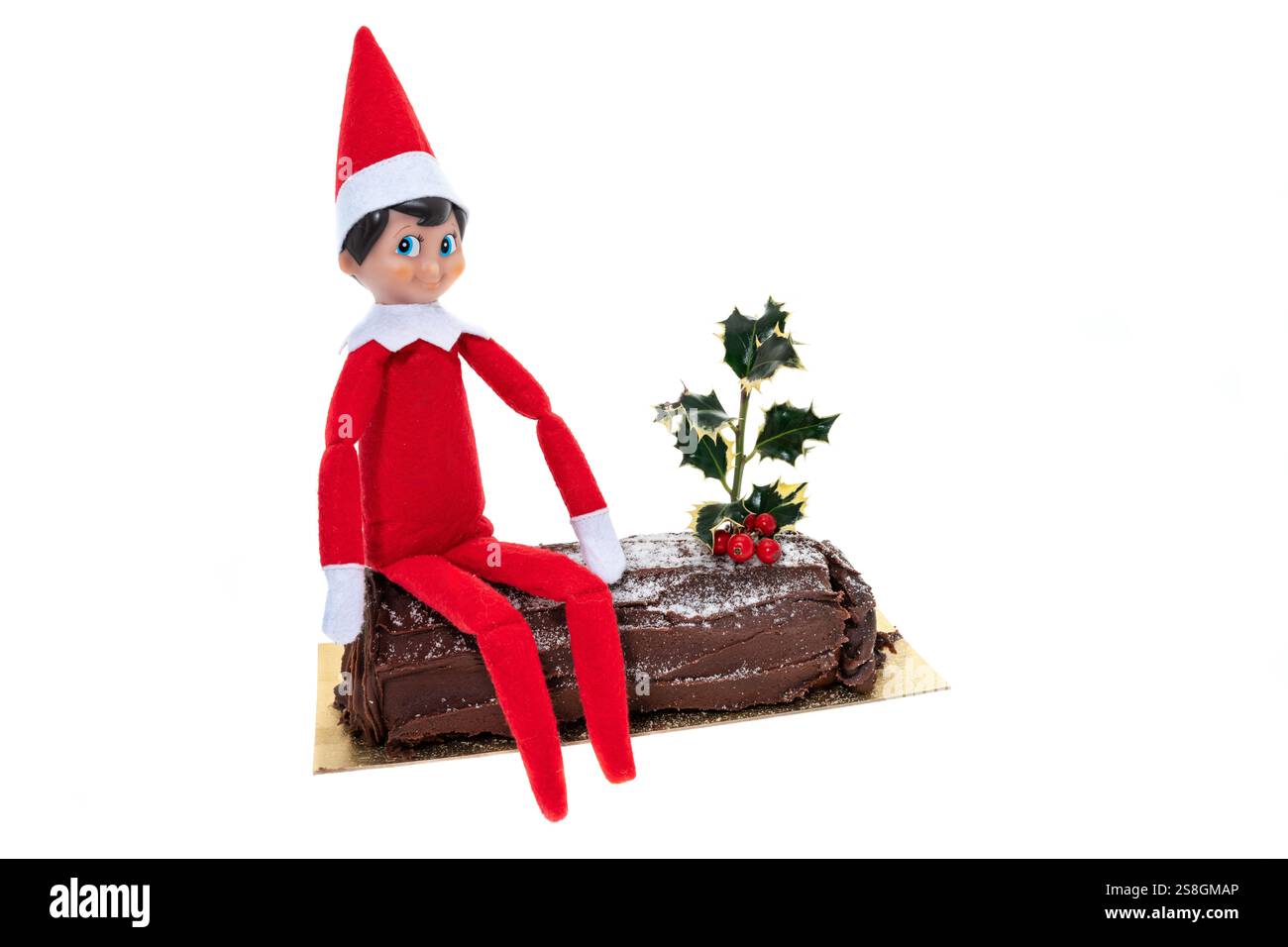 A Christmas pixie elf sat on a chocolate yule log. - white background ...