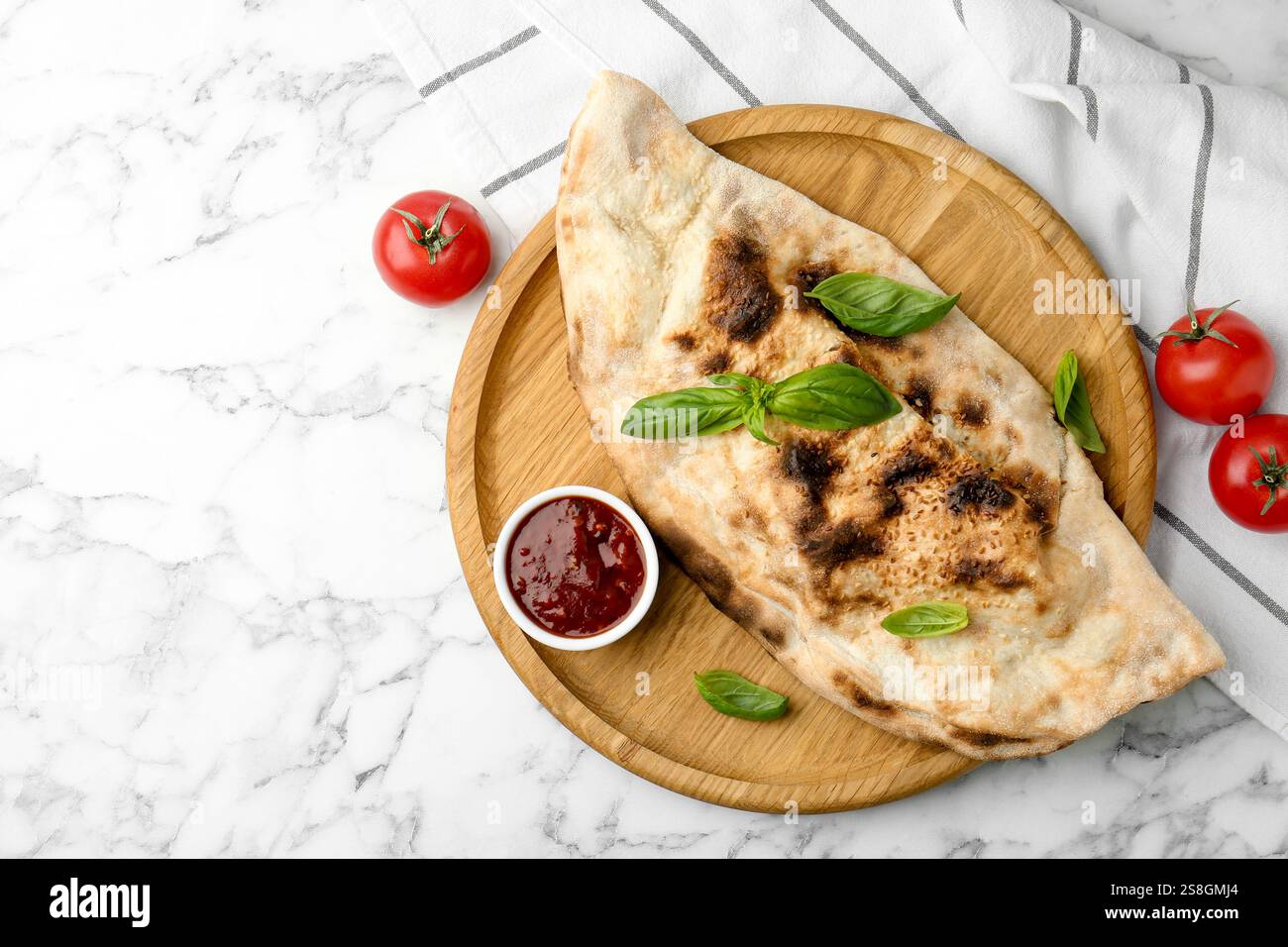 Delicious calzone served on white marble table, top view. Space for ...