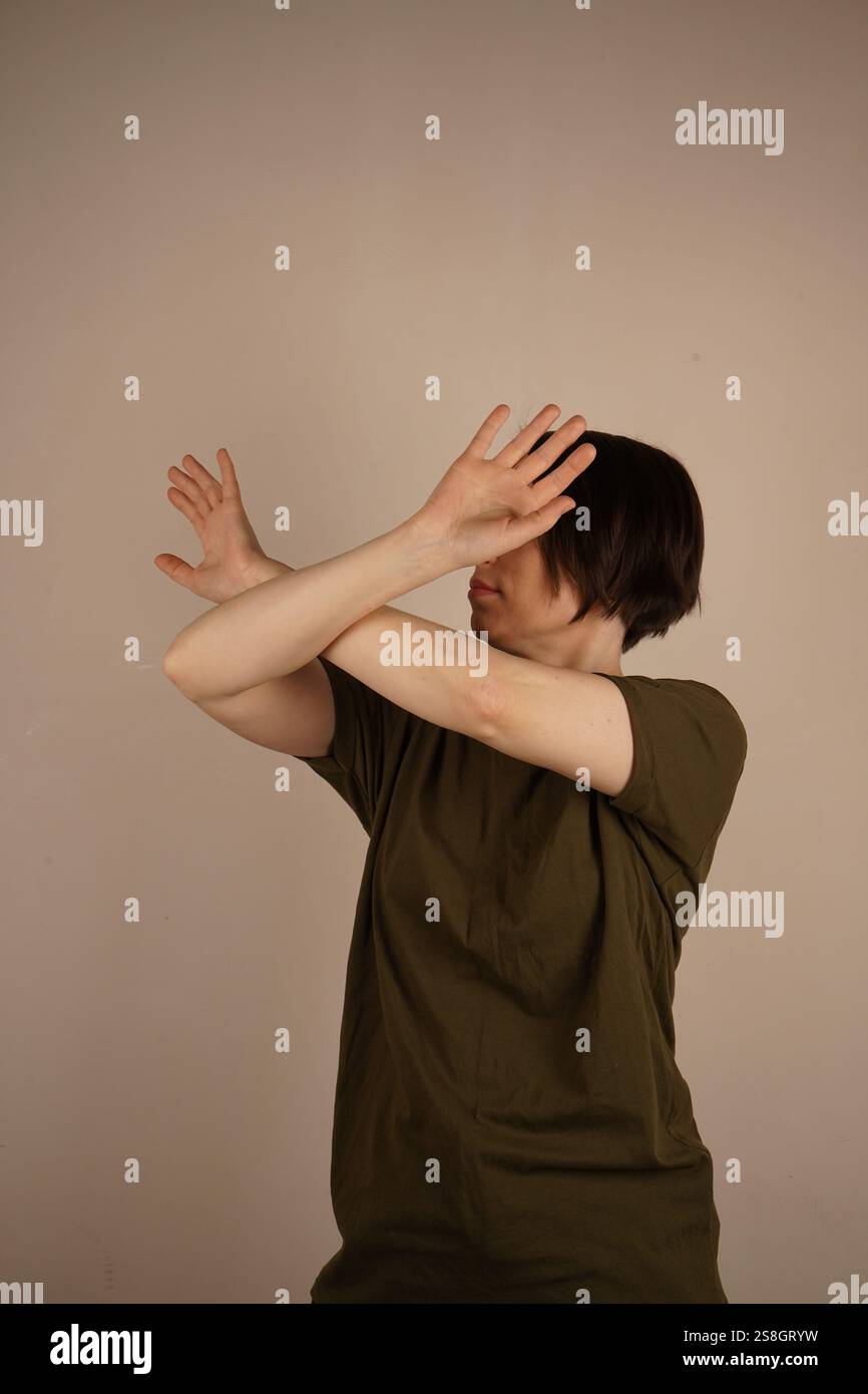 Sad scared woman covers her face with her hands and cries. Lonely girl ...