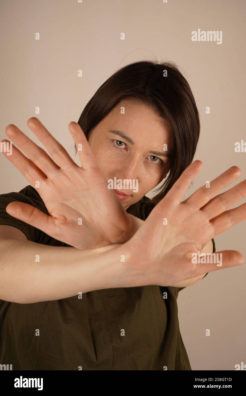 A beautiful young lady covers half of her face with her hand. A woman ...