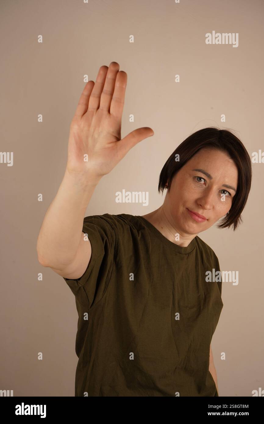 Pretty young woman shows stop sign, hand to camera, symbol of do not ...