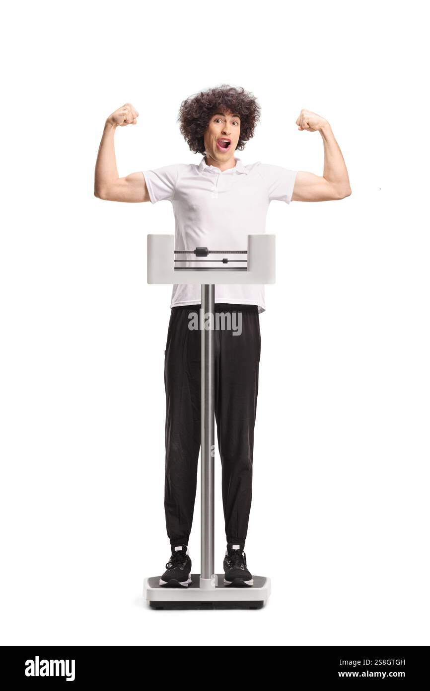 Young man in tracksuit standing on a weight scale and showing arm ...