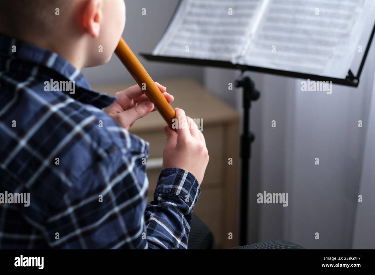 A child playing a wooden reed pipe, showcasing skill and concentration ...