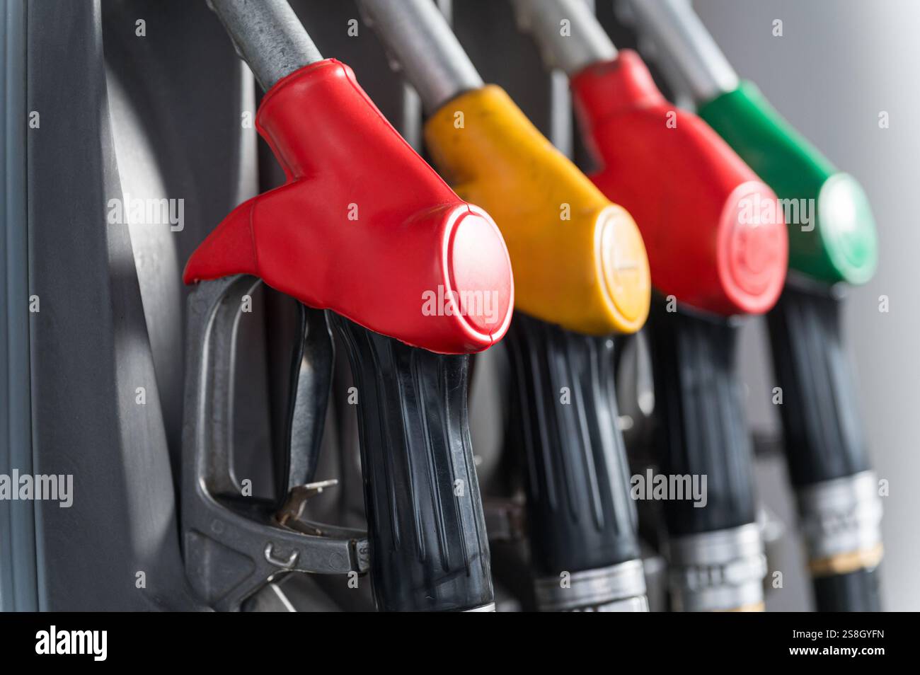 Colorful fuel pump nozzles at a modern gas station. Red, yellow, and ...